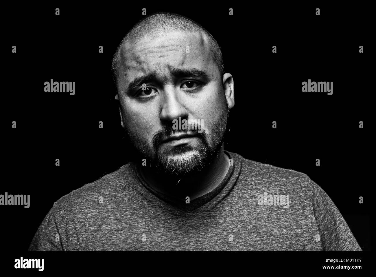 A high contrast black and white emotional and sad portrait of a ...