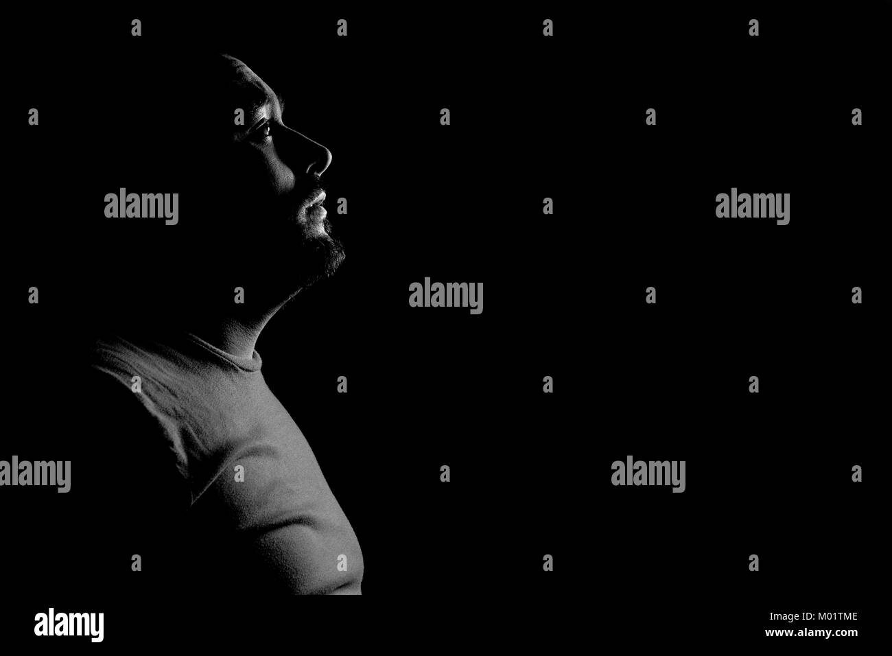 A high contrast black and white profile portrait with plenty of copy ...