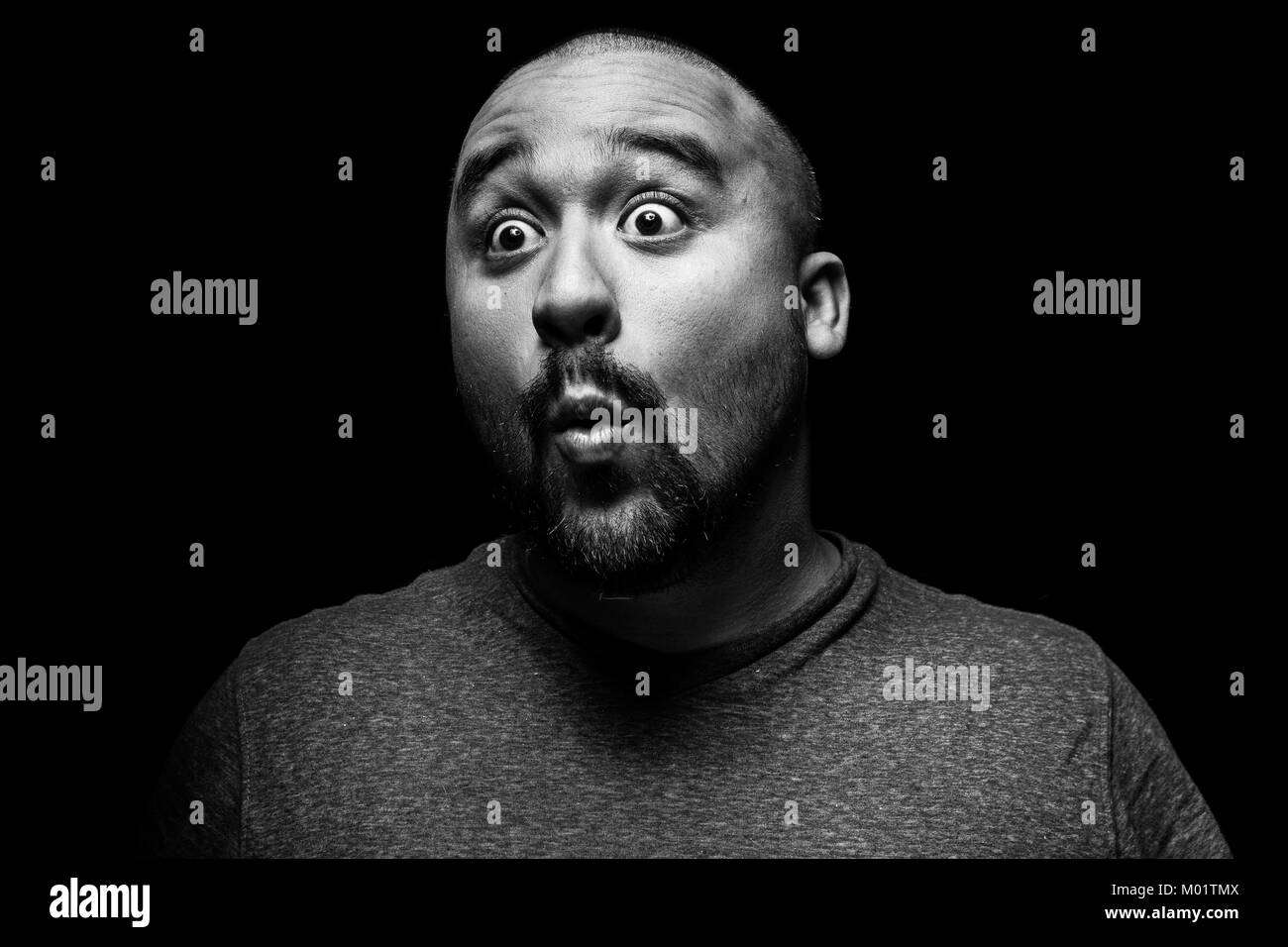 A high contrast black and white emotional and surprised portrait of a ...