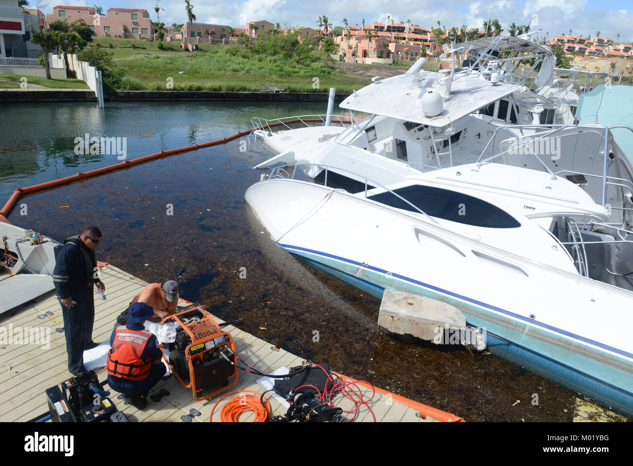 Members of the Hurricane Maria ESF-10 response work to dewater vessels ...