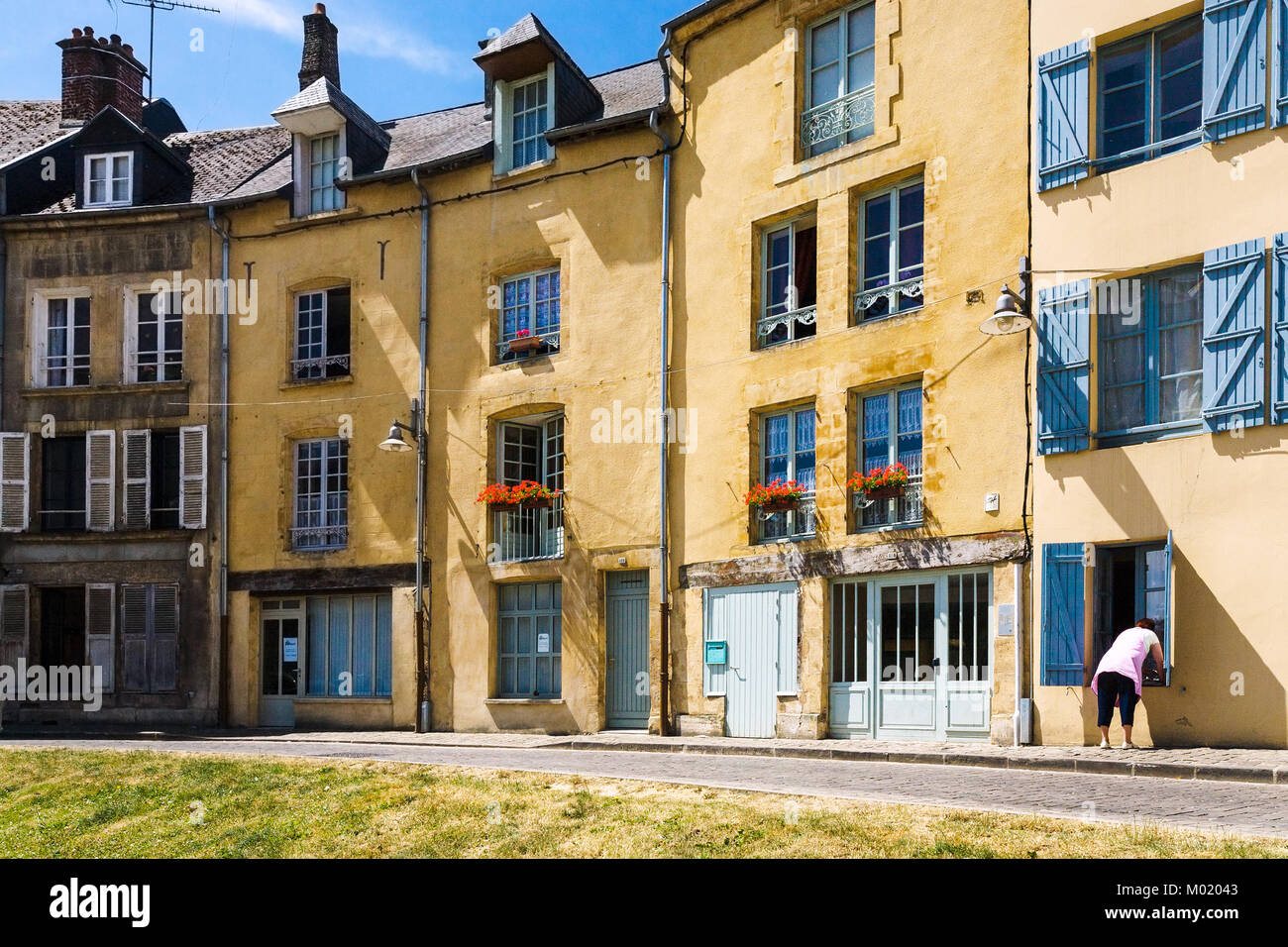 SEDAN, FRANCE - JUNE 30, 2010: woman near residential houses on square ...