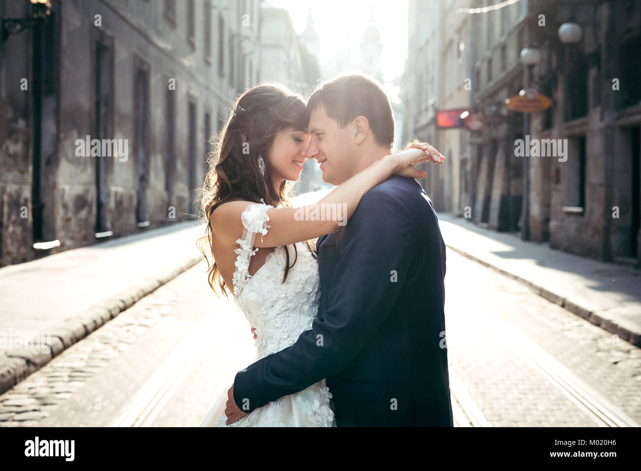 Horizontal romantic portrait of the loving newlywed couple hugging and ...