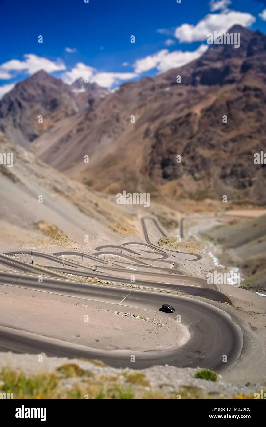 Car driving uphill on the twisting and turning switchback road through ...