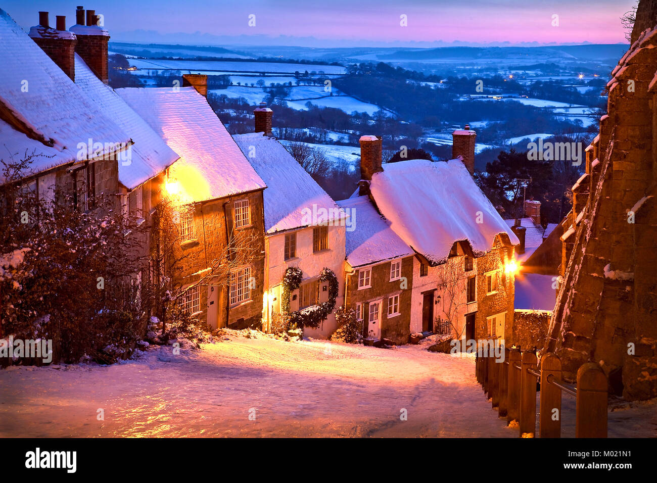 Gold Hill Shaftesbury Dorset after a fall of snow and lit by an evening ...