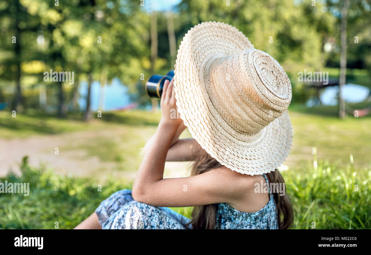 Pretty, cheerful girl watching with the binoculars Stock Photo - Alamy