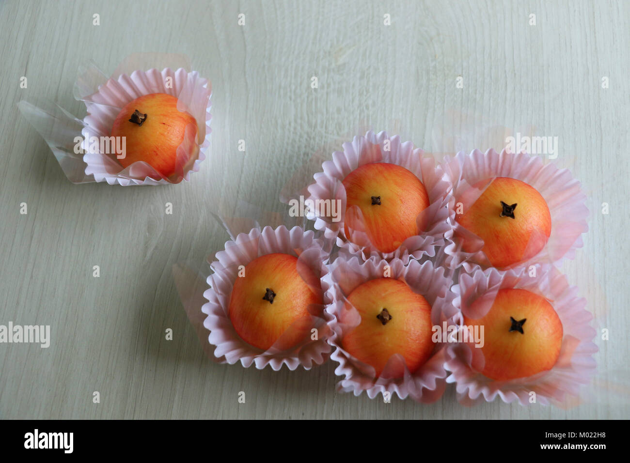 Beautiful red and yellow candies, known as “little apples” made with ...