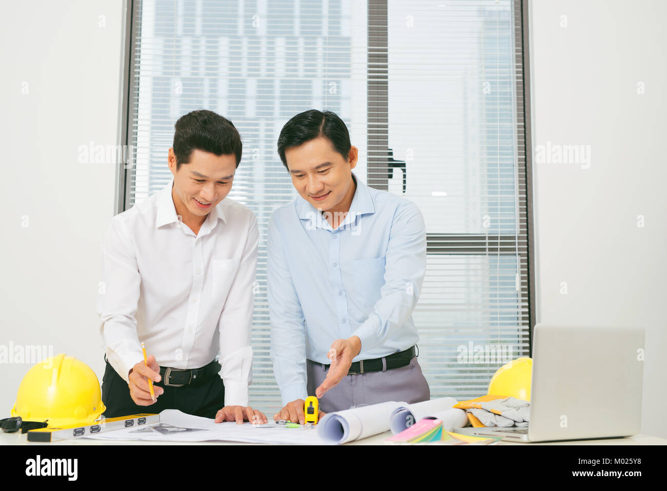 Architects engineer discussing at the table with blueprint of ...