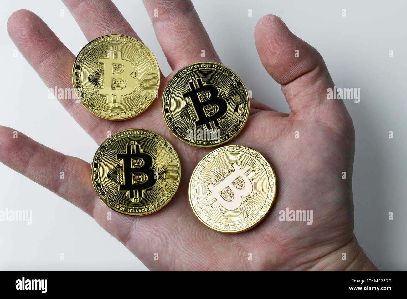 Hand holding four bitcoin on a white background. Modern currency. The ...