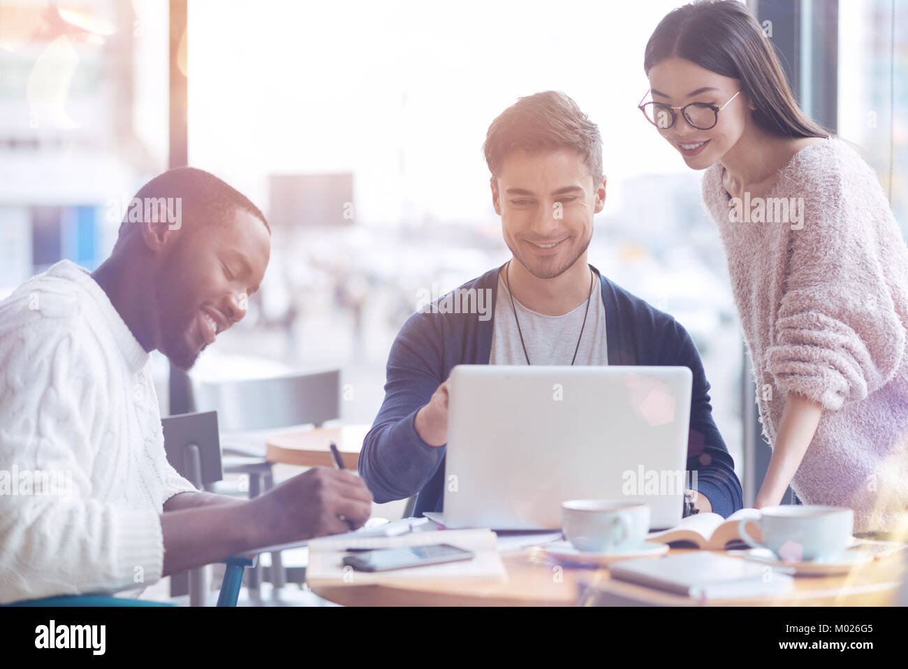 Positive colleagues working together at cafe Stock Photo - Alamy