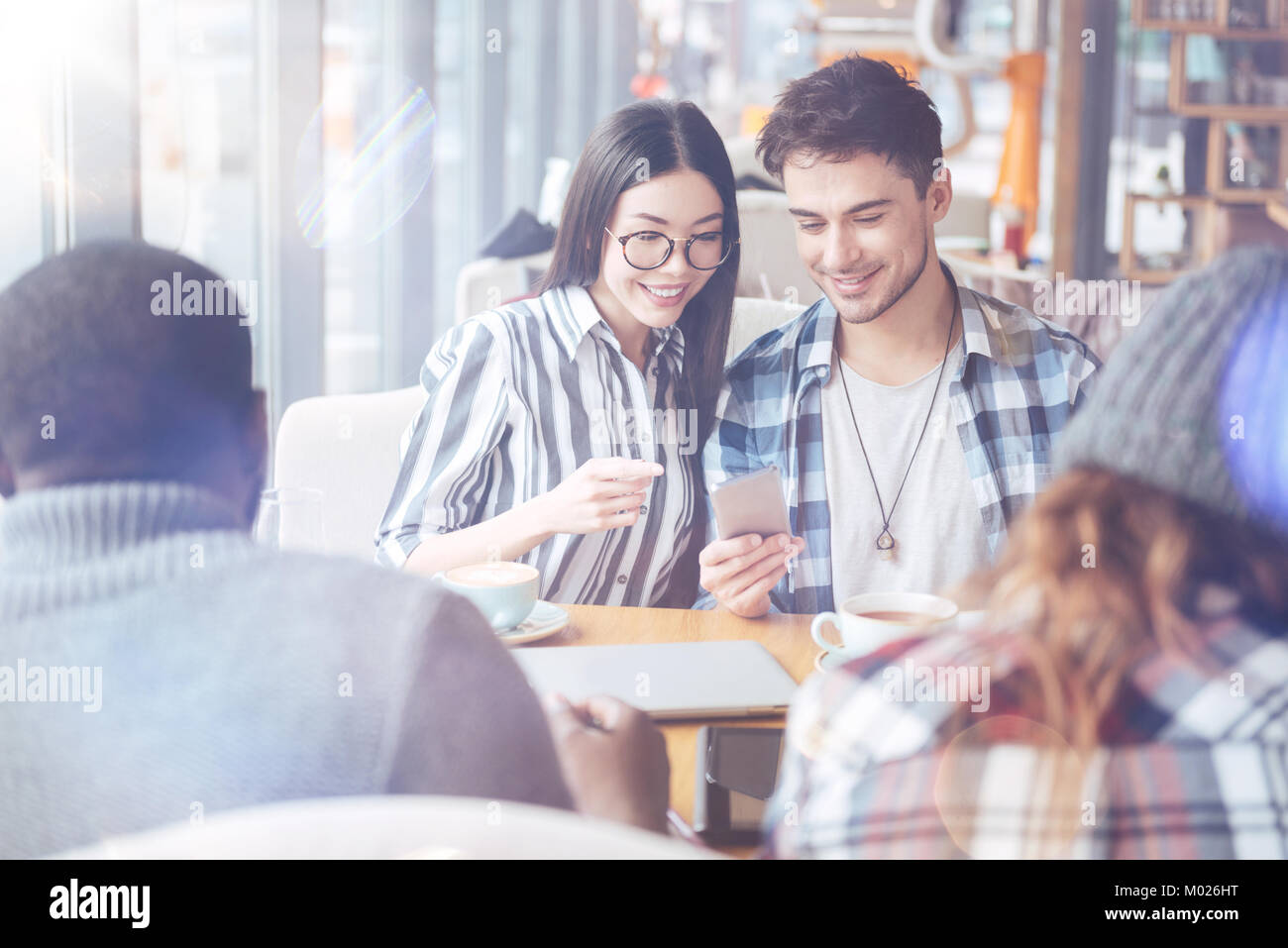 Friendly colleagues choosing photo on telephone Stock Photo - Alamy