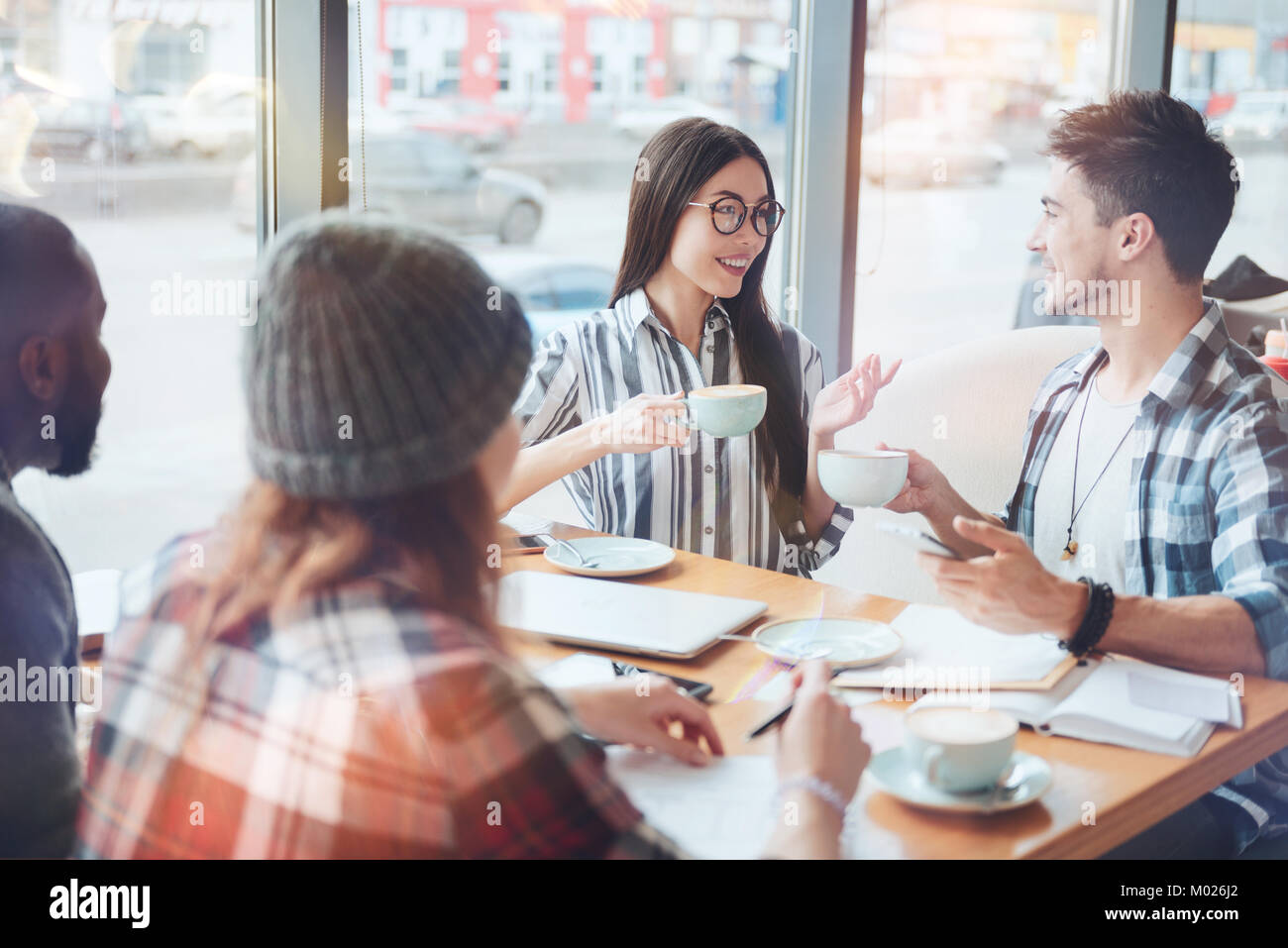 Positive young people discussing funny situation Stock Photo - Alamy