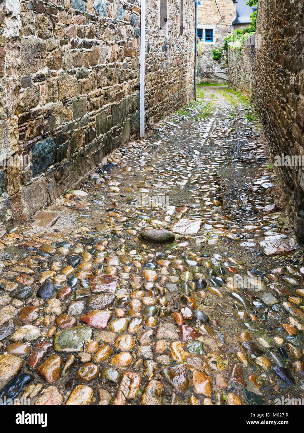 travel to France - wet pavement of narrow street in Treguier town in ...