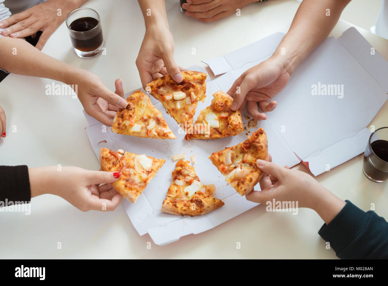 People eat fast food. Friends hands taking slices of pizza Stock Photo ...