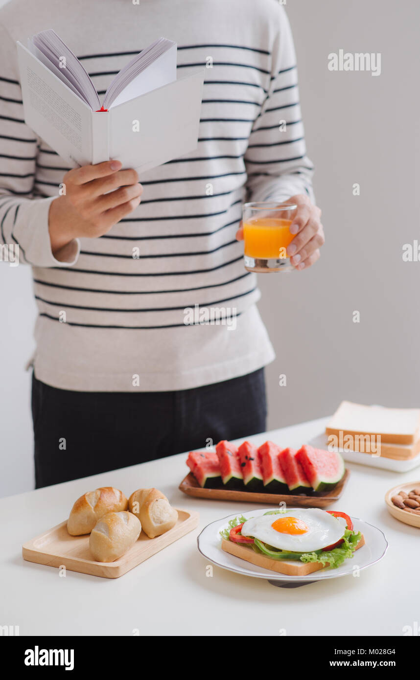 Woman reading book eating watermelon hi-res stock photography and ...