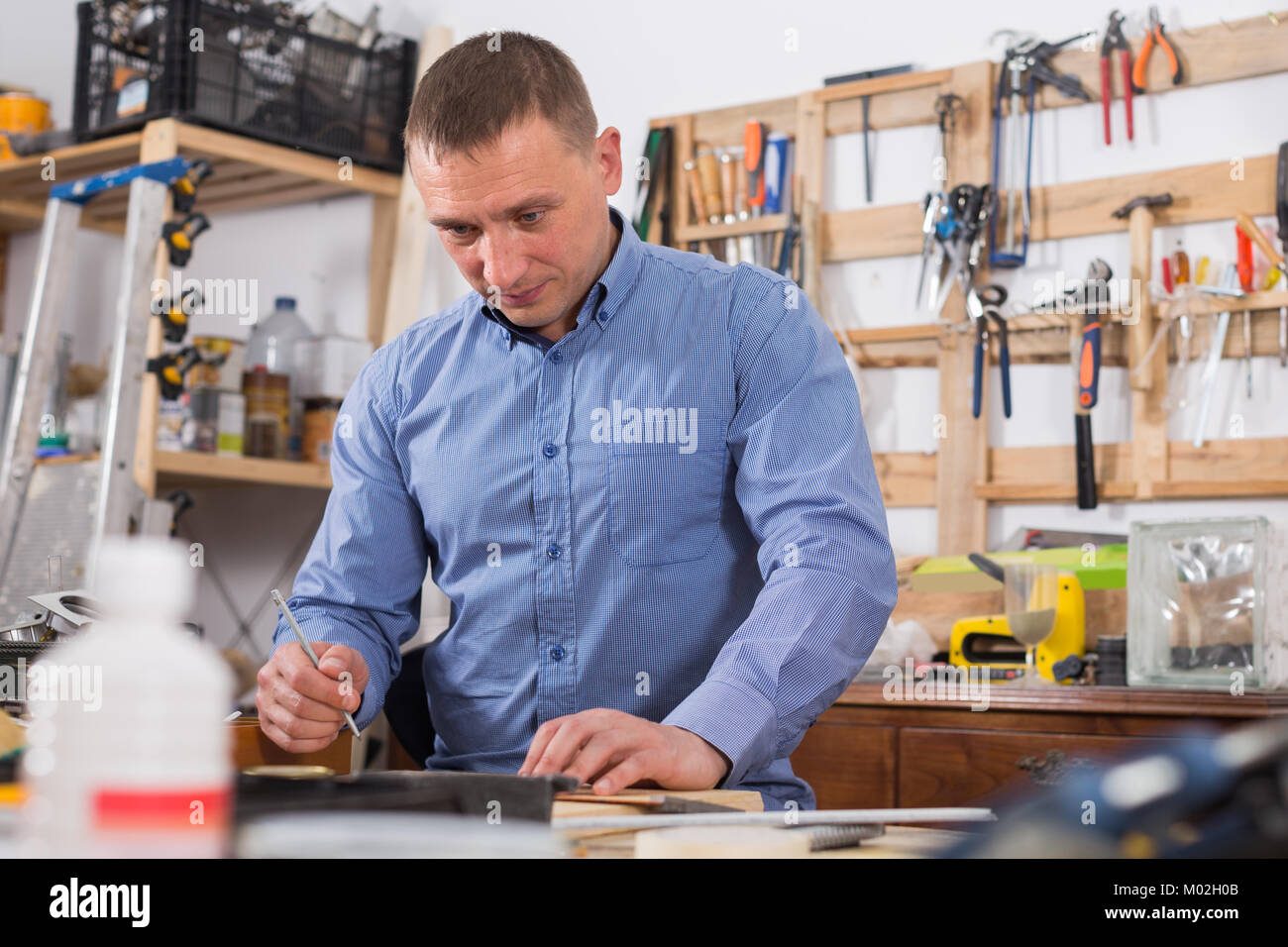 happy young english male carpenter working wood plank at workshop Stock ...