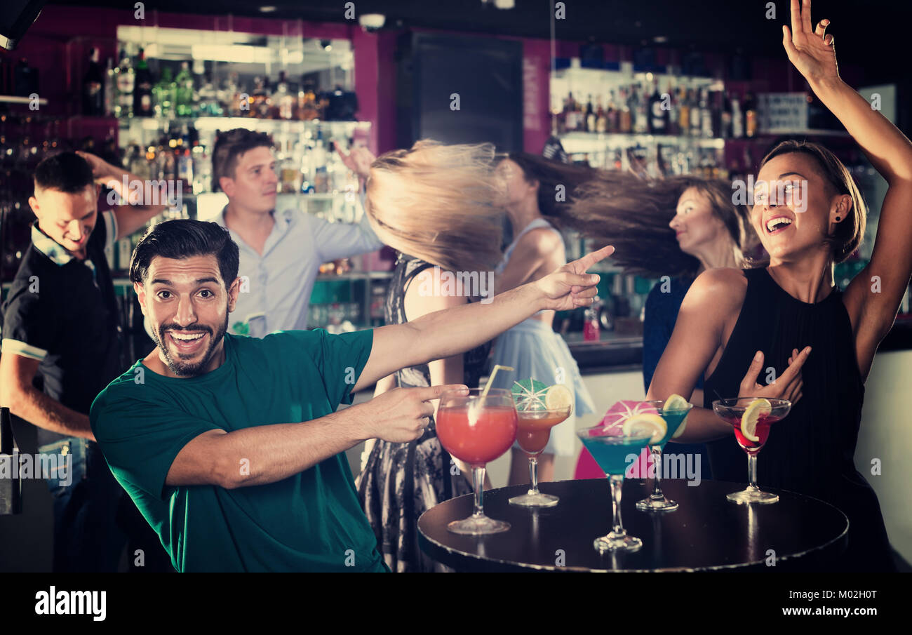 Female with man are dancing and drinking cocktail on the party in bar ...