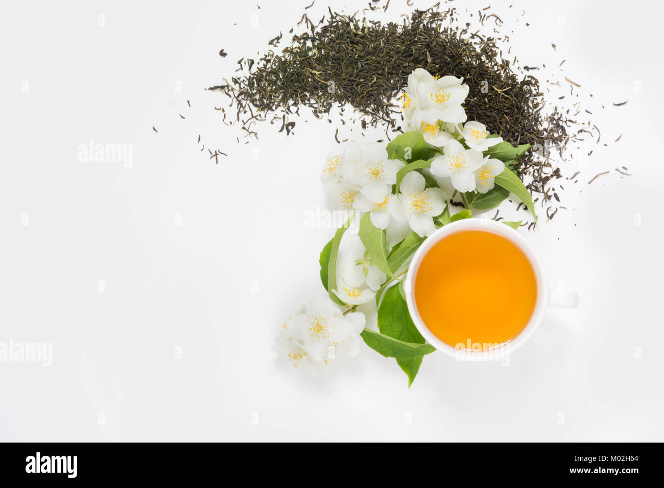 Jasmine dry green tea leaves with jasmine flowers and cup of tea on ...