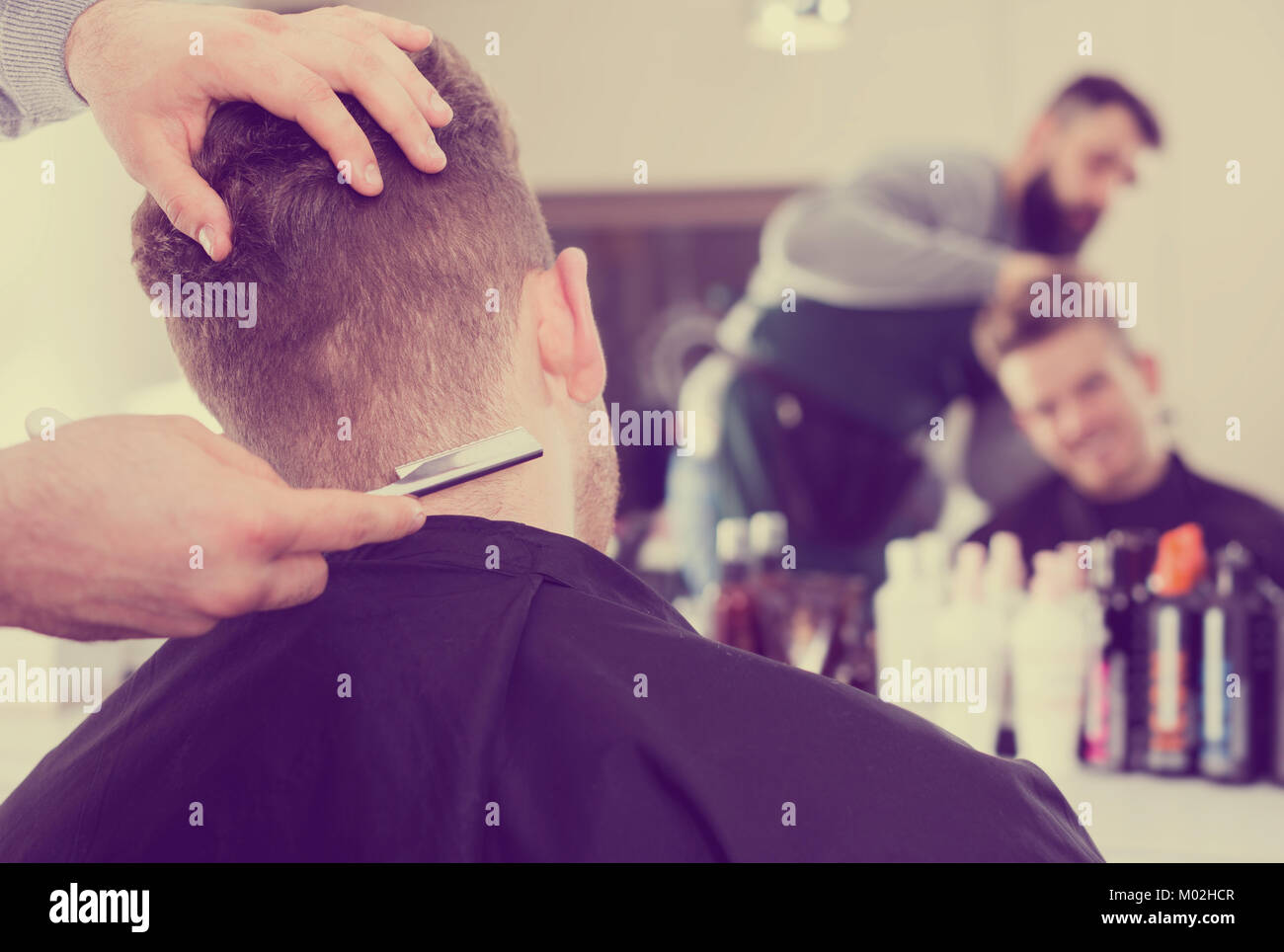 fashionable guy stylist creating new haircut for man client at ...