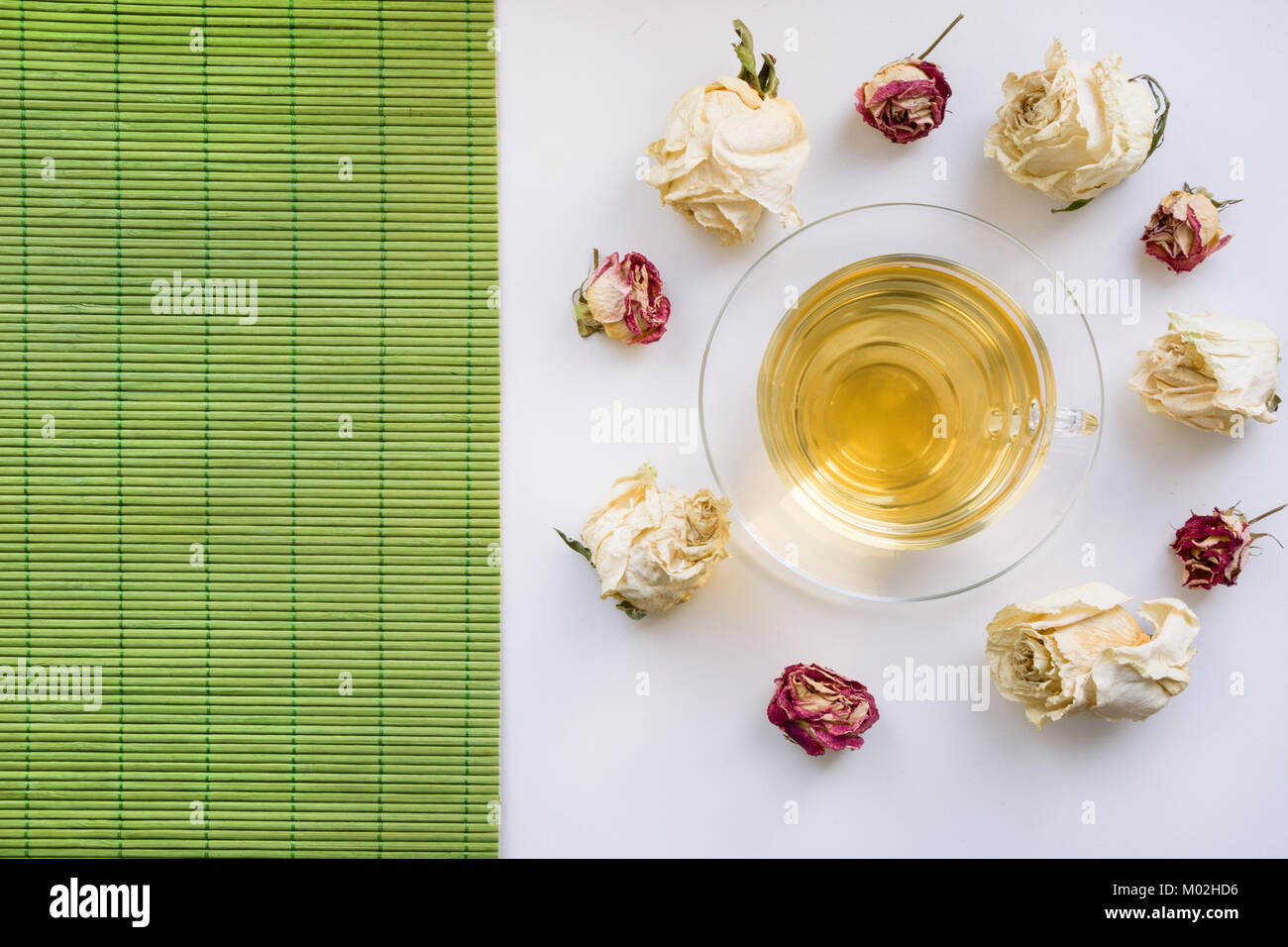 Glass cup of green tea with dry white roses around. Top view Stock ...
