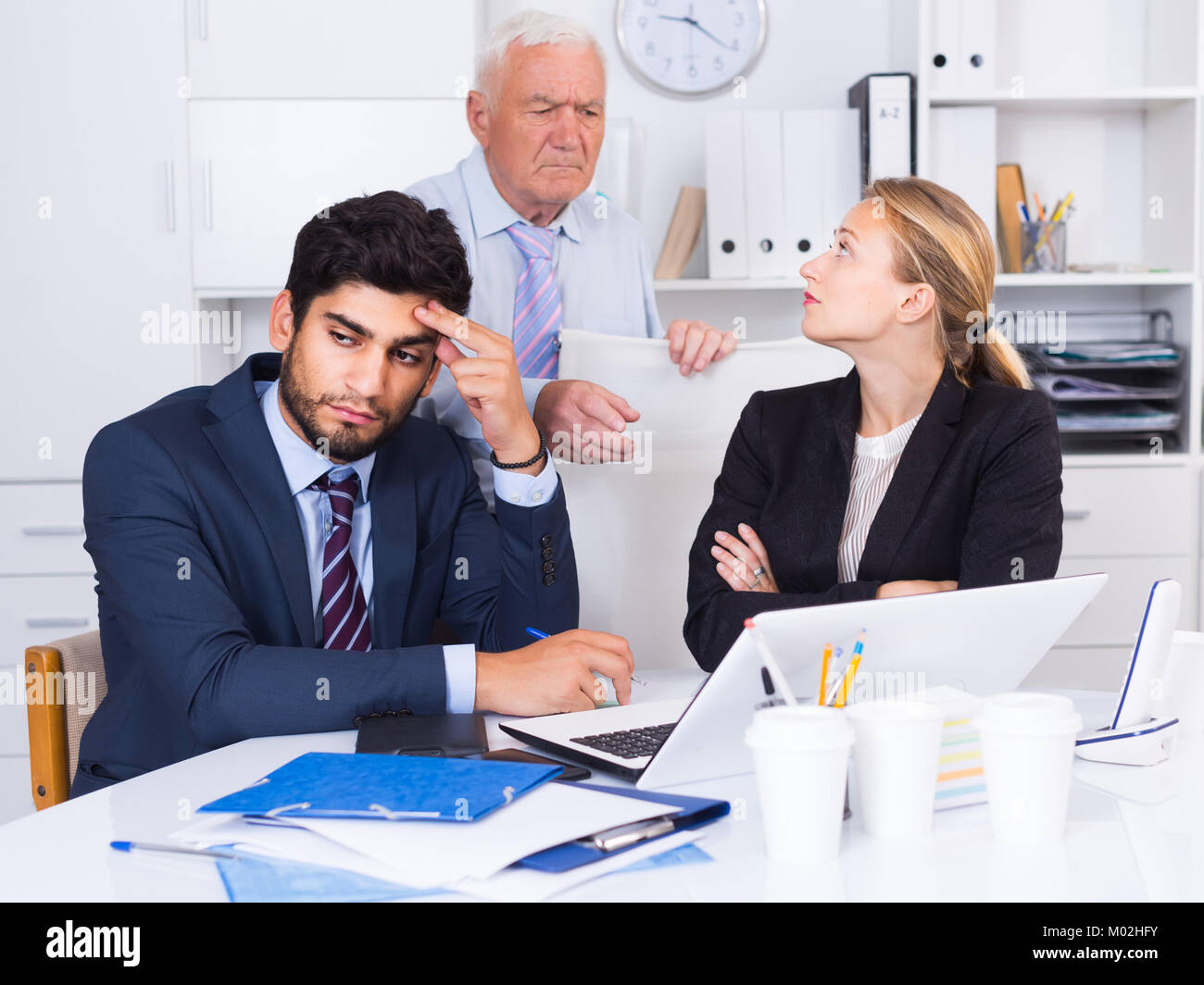Mature boss is chastising employees because of uncompleted work in the ...