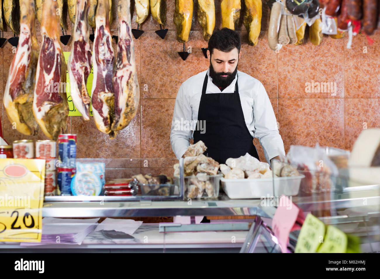 Smiling butcher arranging meat in hi-res stock photography and images ...
