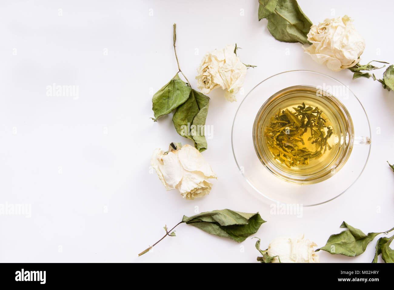 Cup of green tea with dry white roses around. Top view Stock Photo - Alamy