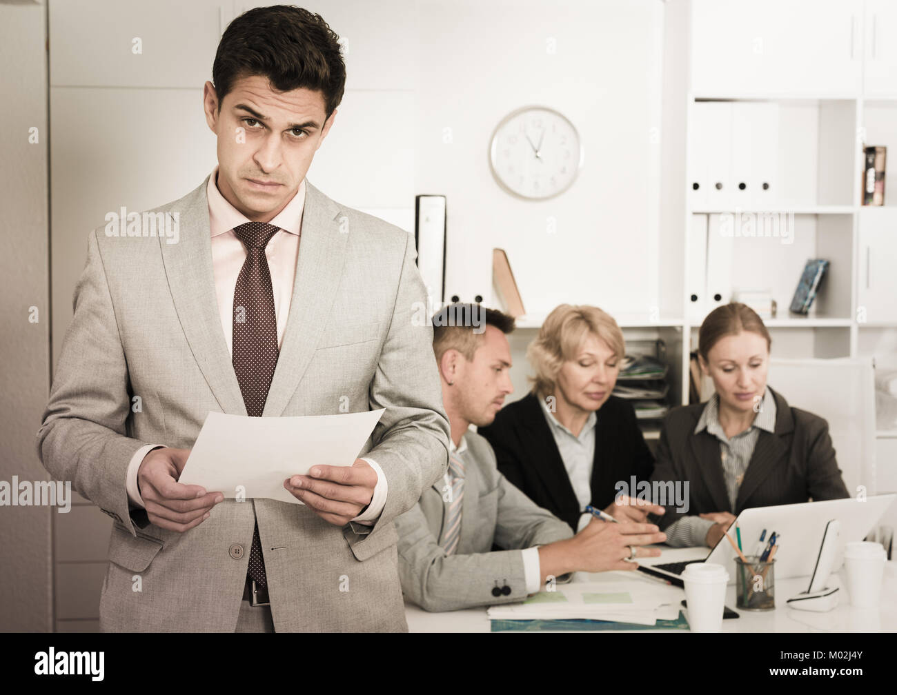Businessman standing apart feeling angry to coworkers in office Stock ...