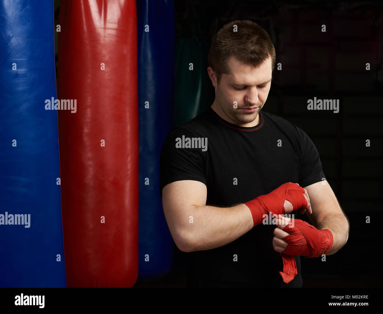 Boxing man applying hand bandage on modern gym background Stock Photo ...