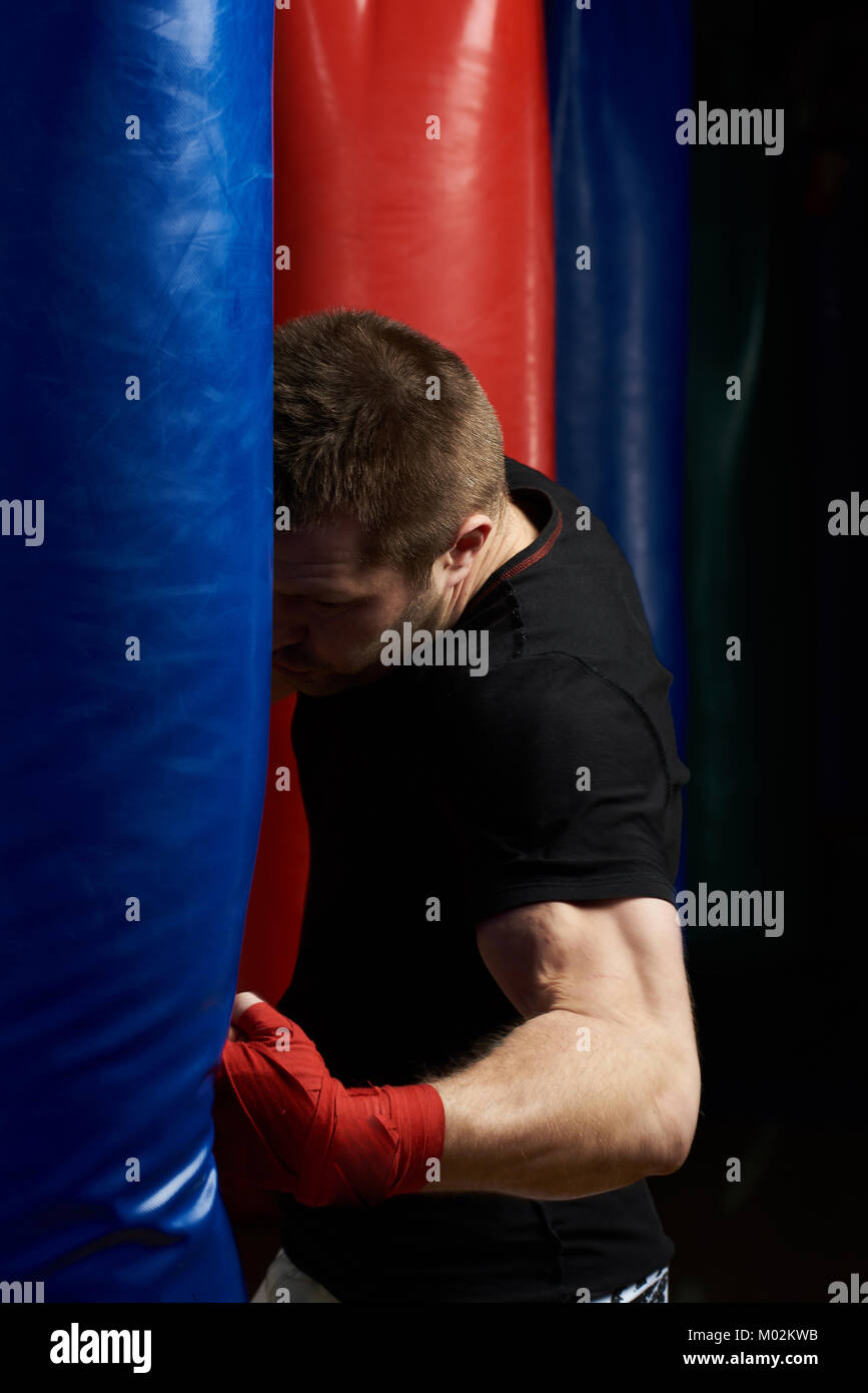 Strong punch of boxing man to punching bag in gym background Stock ...