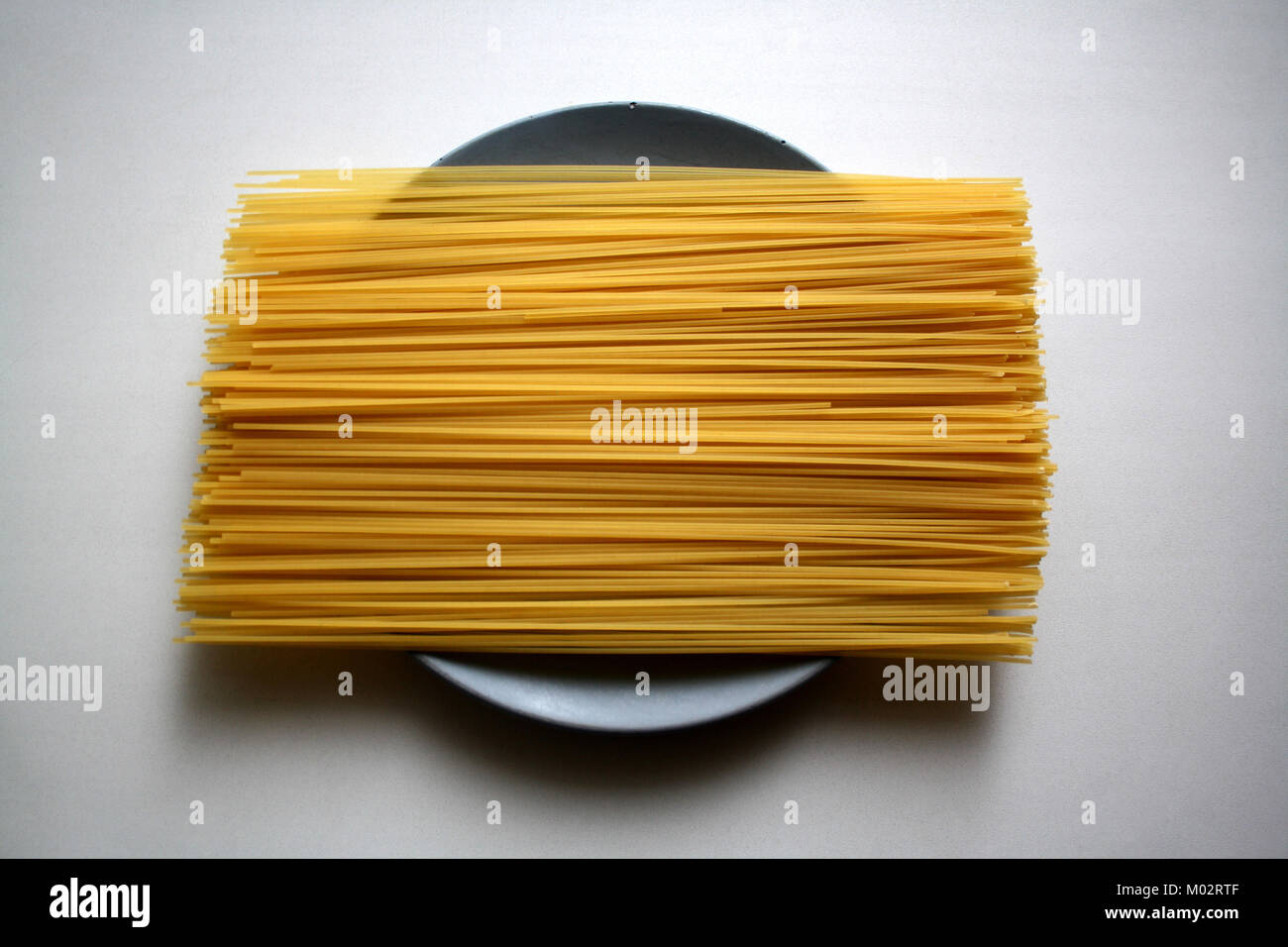 Stack of spaghetti isolated on grey concrete plate from a high angle ...