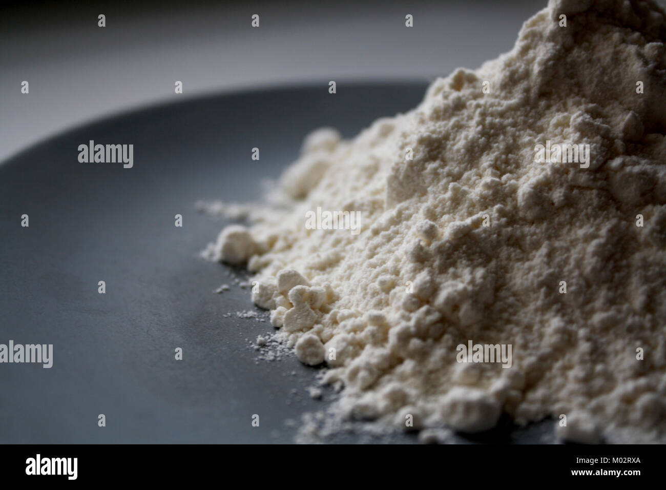 Wheat flour mountain hill on a grey plate close up Stock Photo - Alamy