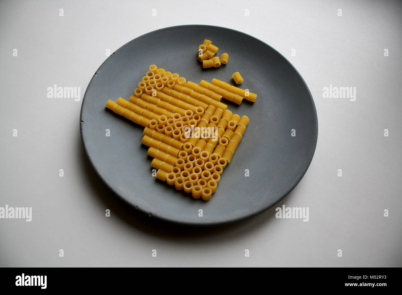 Ditalini pasta puzzle with unordered items on a grey concrete plate ...