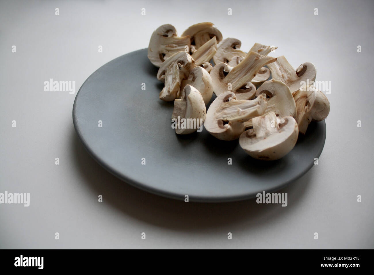 Cut champignons isolated on a side of grey concrete plate Stock Photo ...