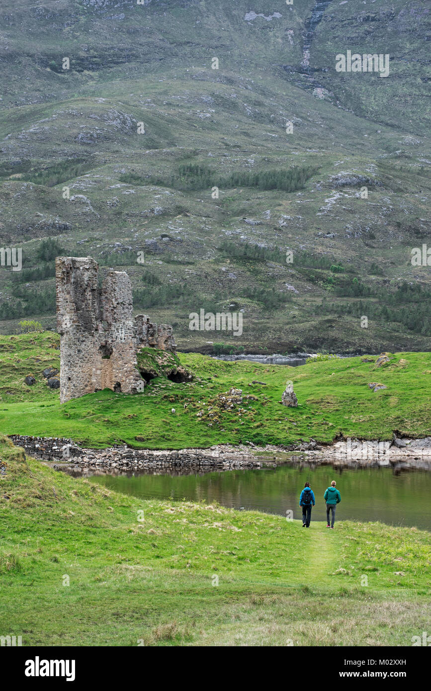 Tourists visiting 16th century Ardvreck Castle ruin at Loch Assynt in ...