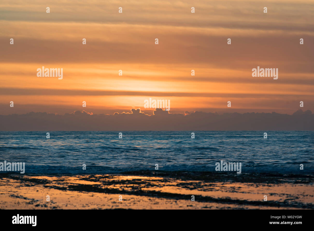 A pre dawn view over a rock ledge to the ocean on the east coast of ...