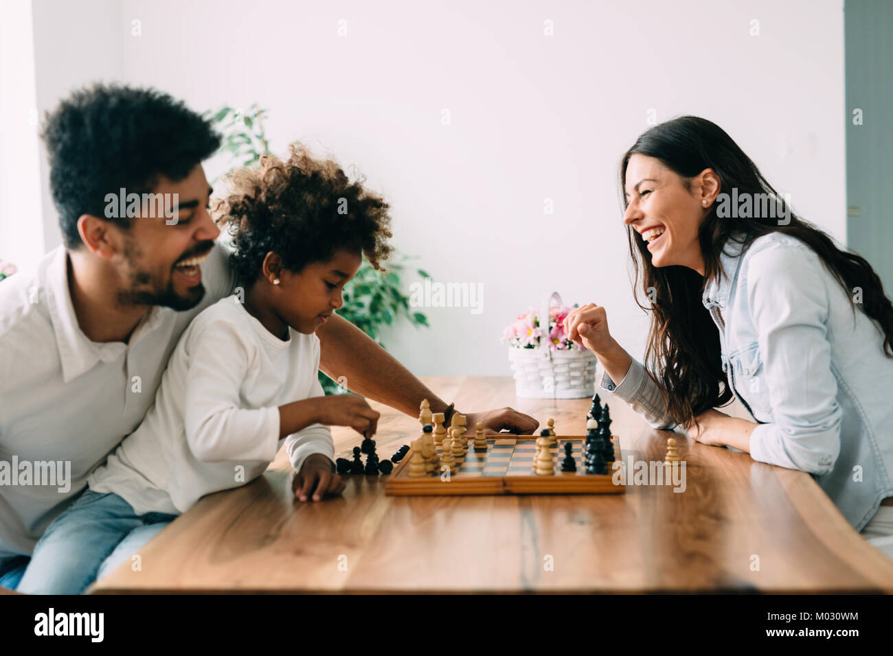 Happy family playing chess together at home Stock Photo - Alamy