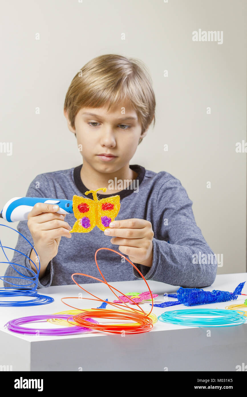 Boy creating with 3d pen Stock Photo - Alamy