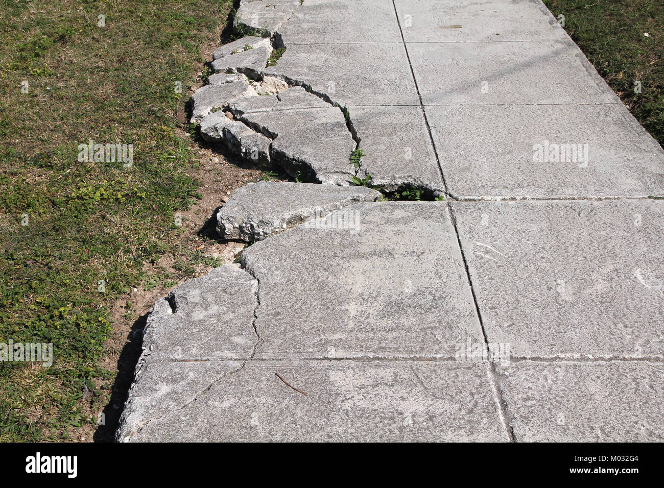 Damaged sidewalk - danger and body harm hazard for pedestrians. Hole in ...