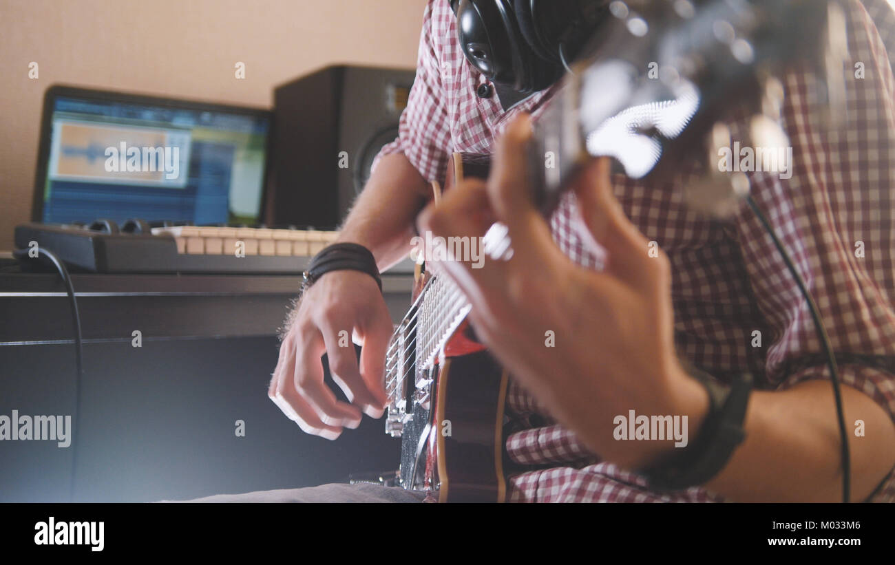 Young musician composes and records music playing the electric guitar ...