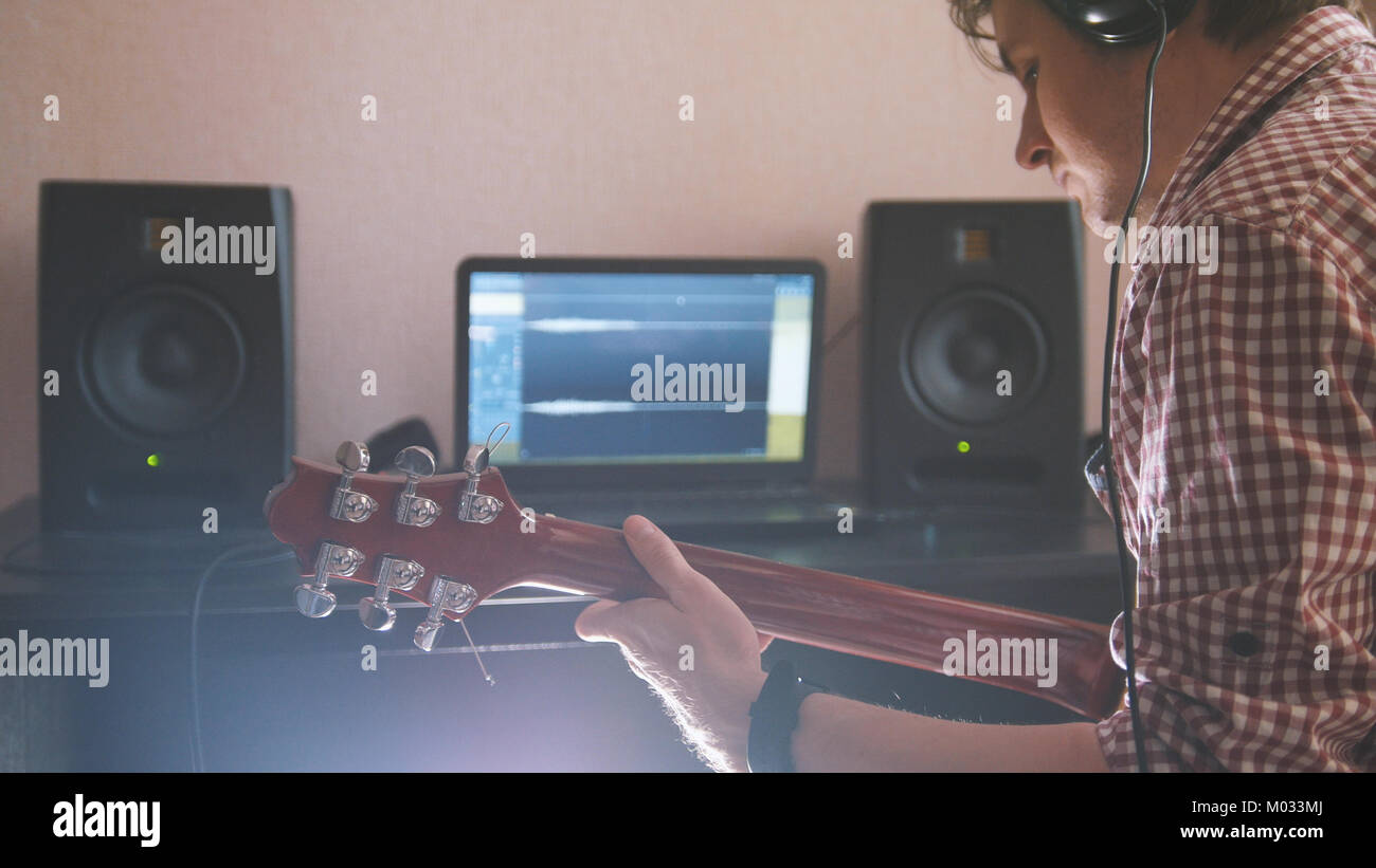 Young musician composes and records music playing the electric guitar ...