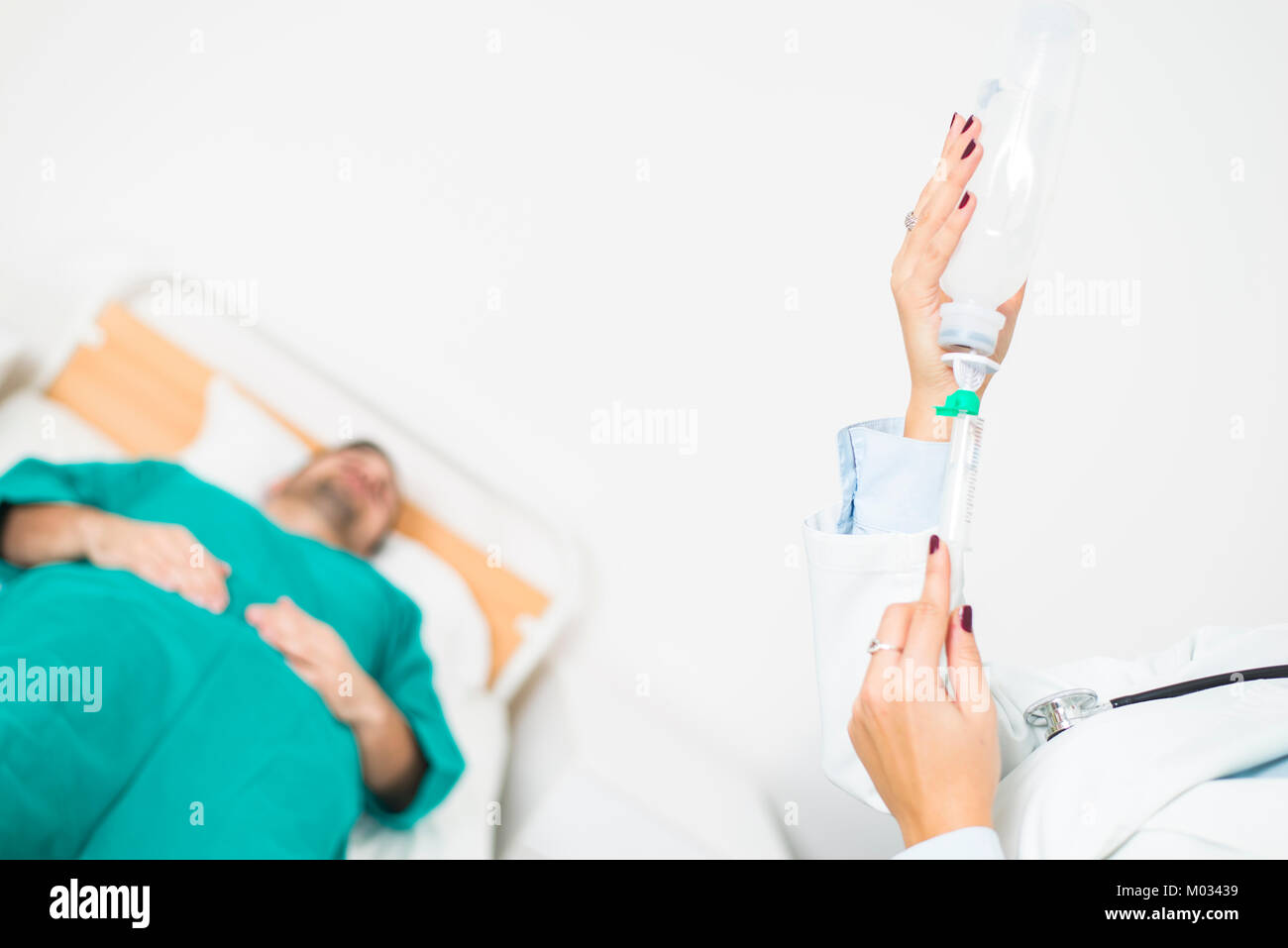 female doctor prepares an injection while the patient is in bed at ...