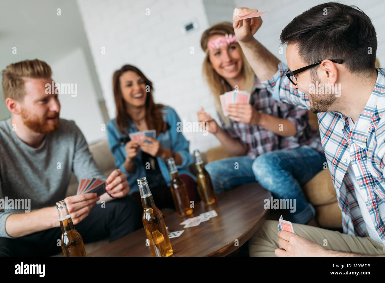 Happy group of friends playing cards and drinking Stock Photo - Alamy
