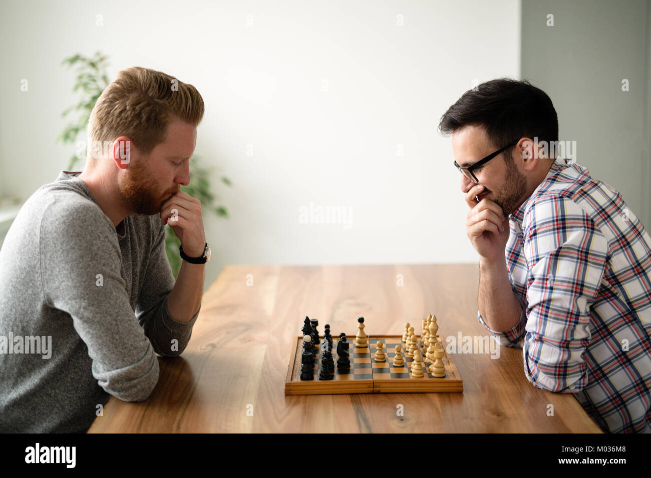 Portrait of two young man playing chess Stock Photo - Alamy