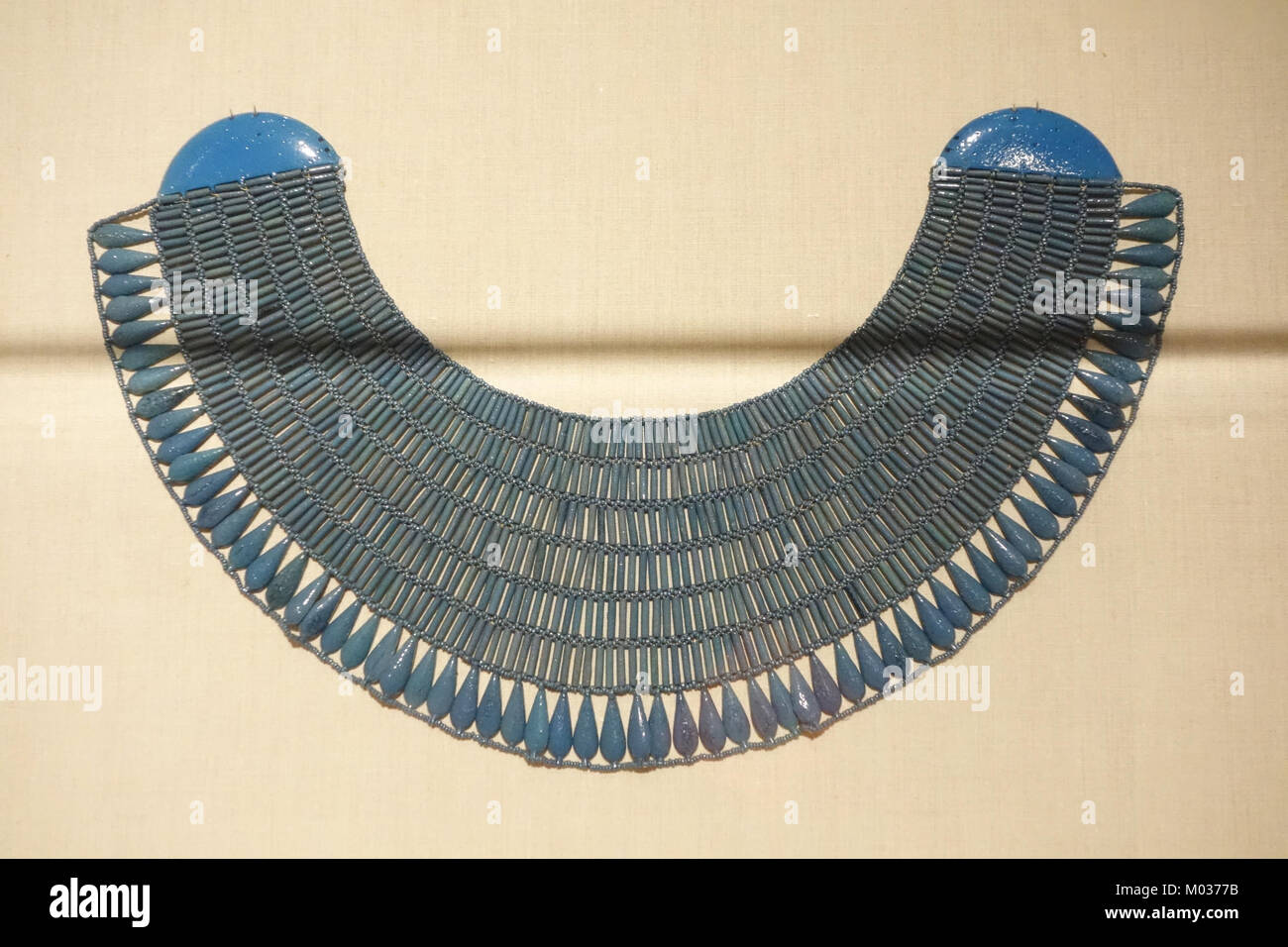 This broad collar, crafted from blue faience, dates back to the New ...