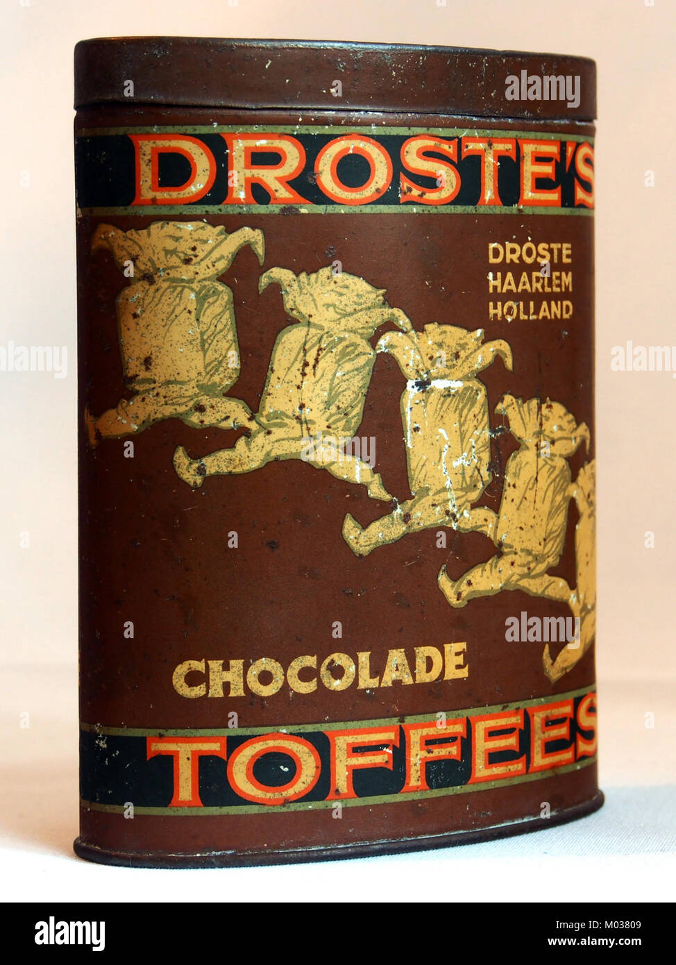 This image shows a brown oval-shaped Droste chocolate toffee tin. The ...