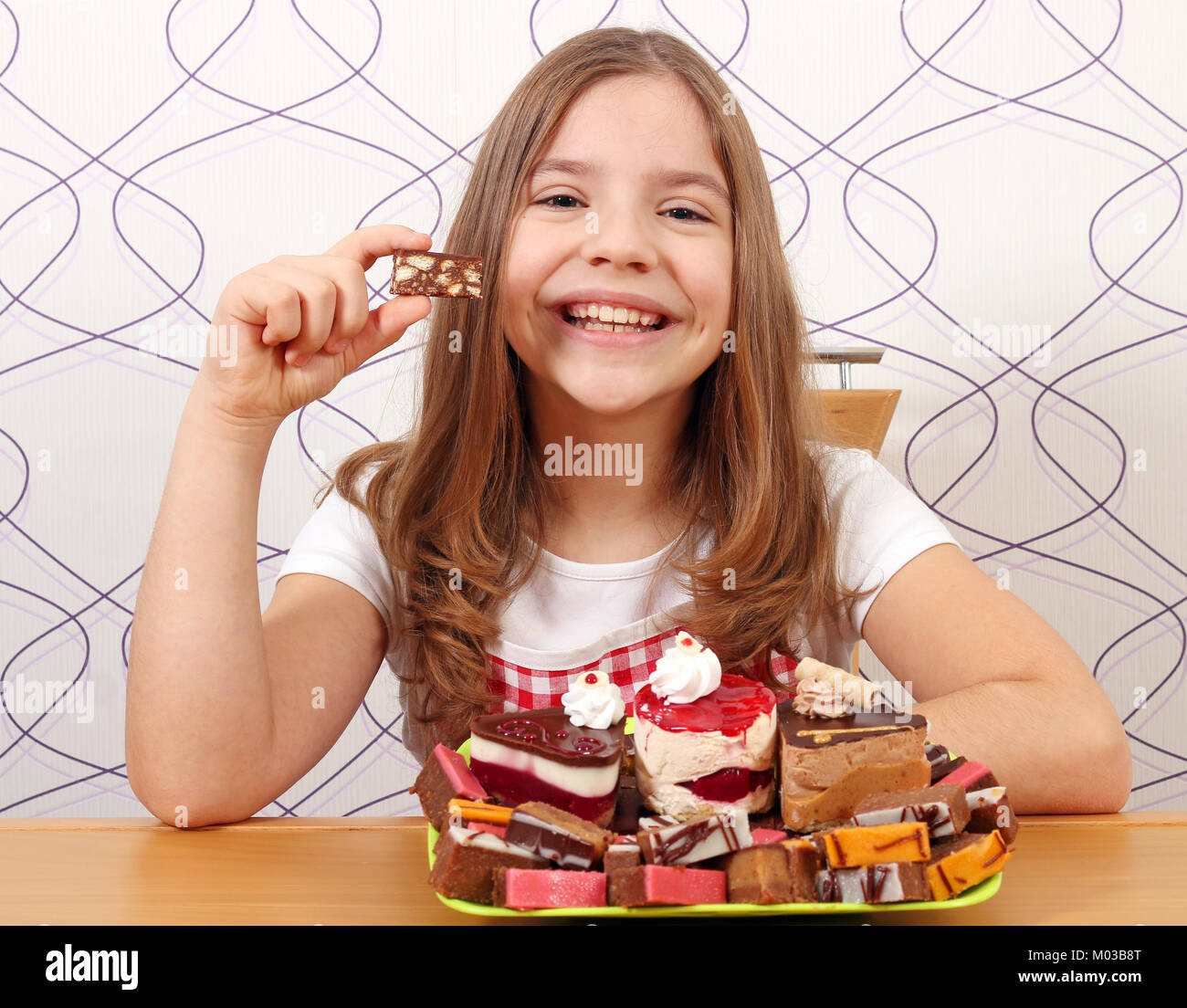 happy little girl eat cake Stock Photo - Alamy