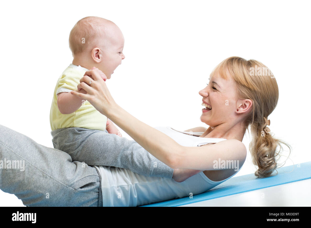 Young mother and baby are doing exercise and having fun isolated on a ...