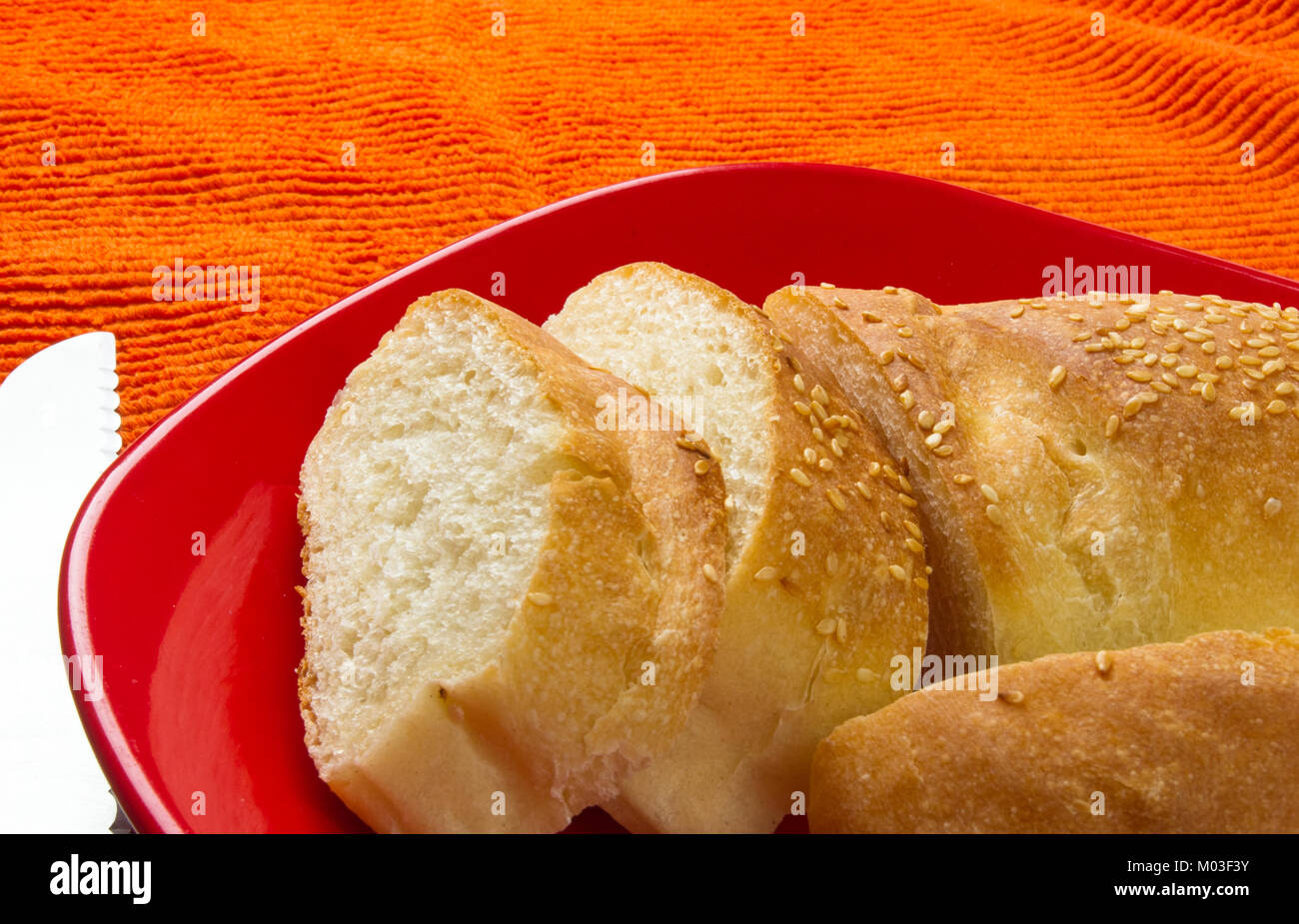 sliced whole wheat breads with a knife on a red plate Stock Photo - Alamy