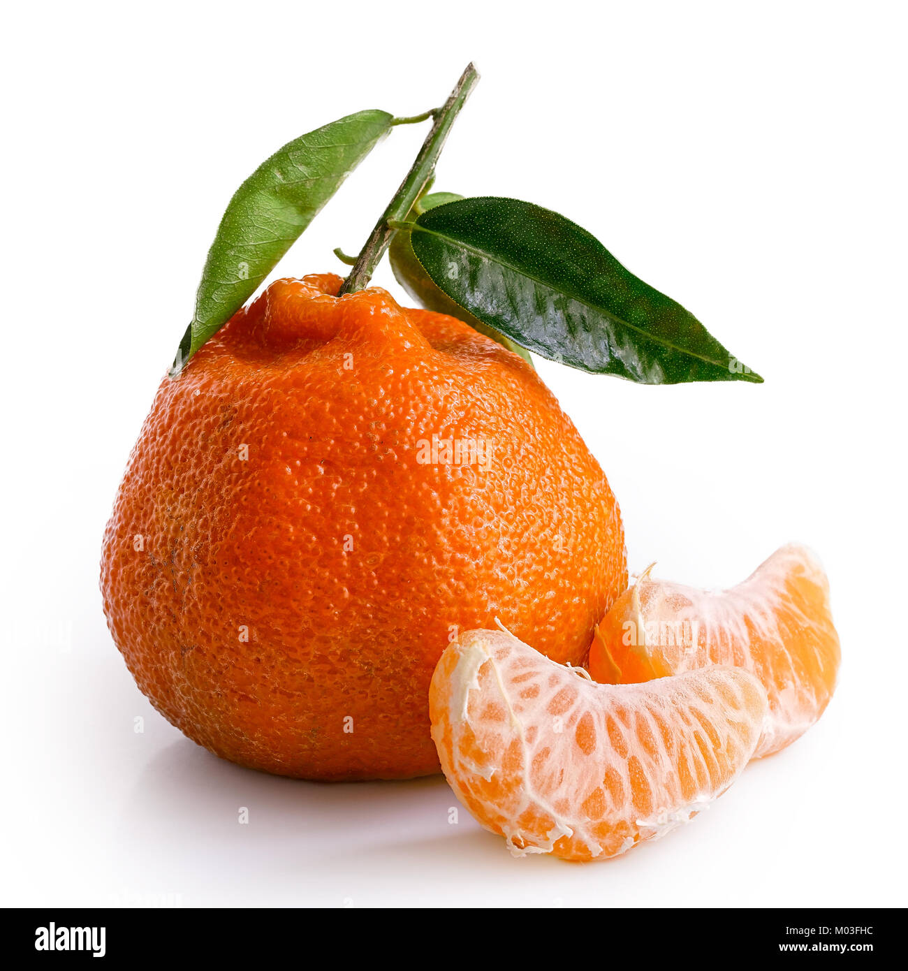 Two segments of a mandarin next to whole mandarin with leaves isolated ...