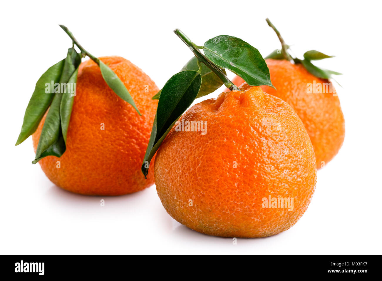 Three whole mandarins with leaves isolated on white Stock Photo - Alamy